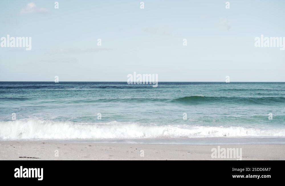 Handheld shot of waves from open ocean washing over sand beach Stock ...