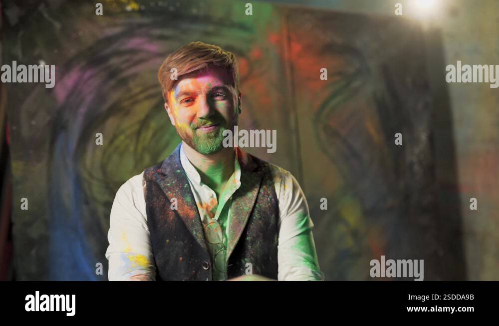 Young dirty in paint artist looks at the camera and smiles Stock Video ...