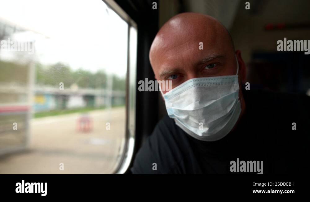 Portrait of a very sad adult bald man with a medical protective mask on ...