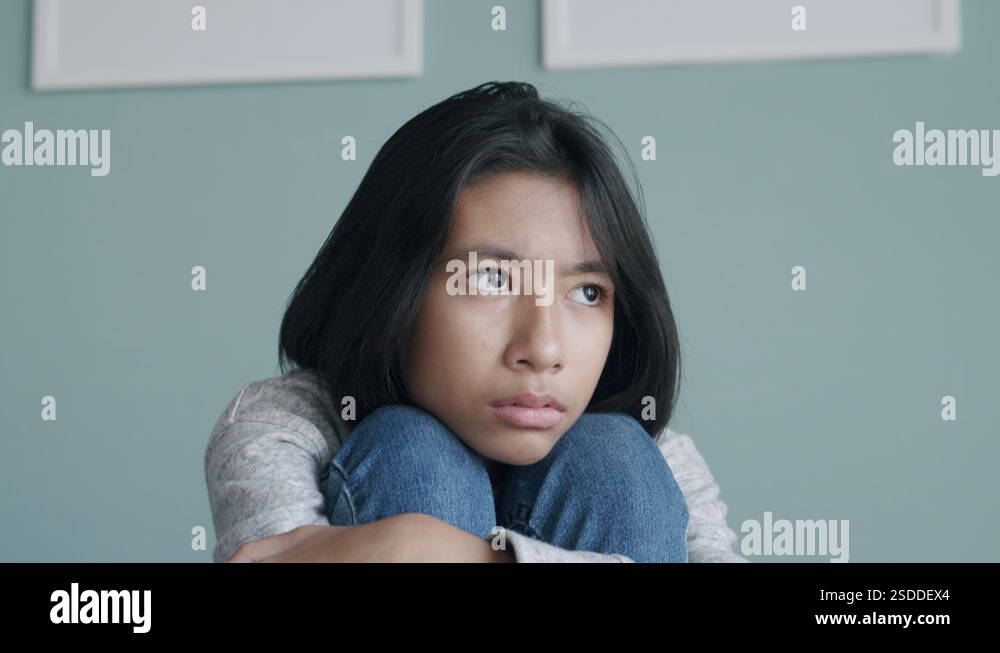 Asian girl is sitting sadly and hug her knee on the sofa Stock Video ...
