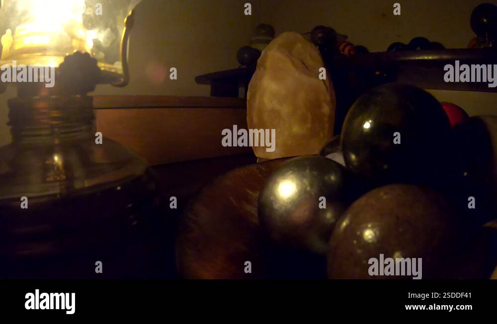 Round shiny ball art in the dark next to a lamp on a table in a living ...