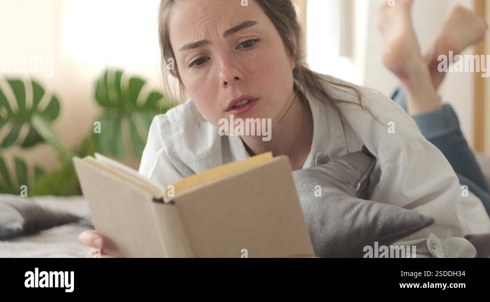 Sad woman crying while reading a book at home Stock Video Footage - Alamy