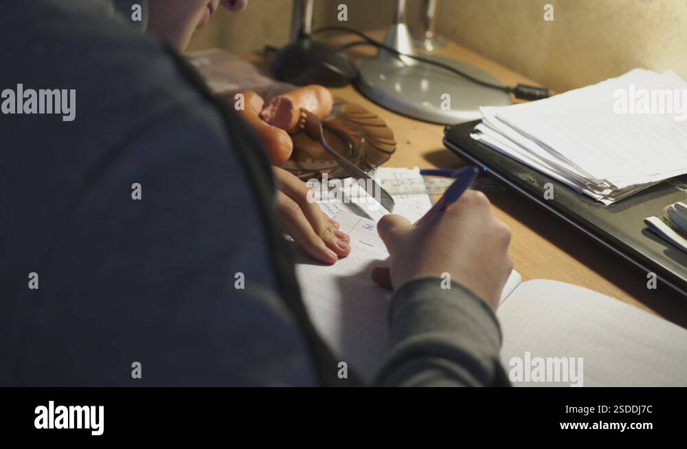 A student who works with documents while studying at home. There is a ...