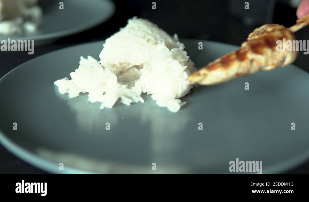 close-up Put three pieces of chicken meat on a plate of ricem, slow ...