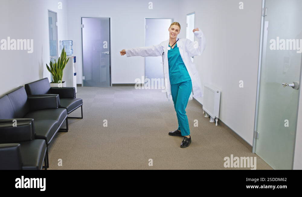 Dancing doctor lady in front of the camera in a modern hospital ...