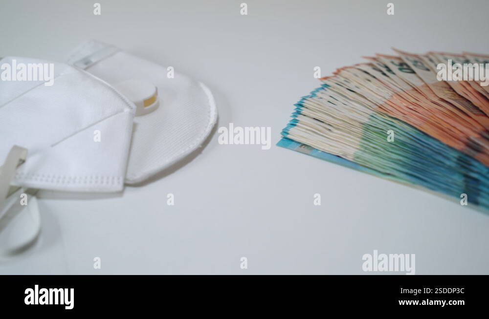 A pile of euro banknotes and two different types of protective medical ...