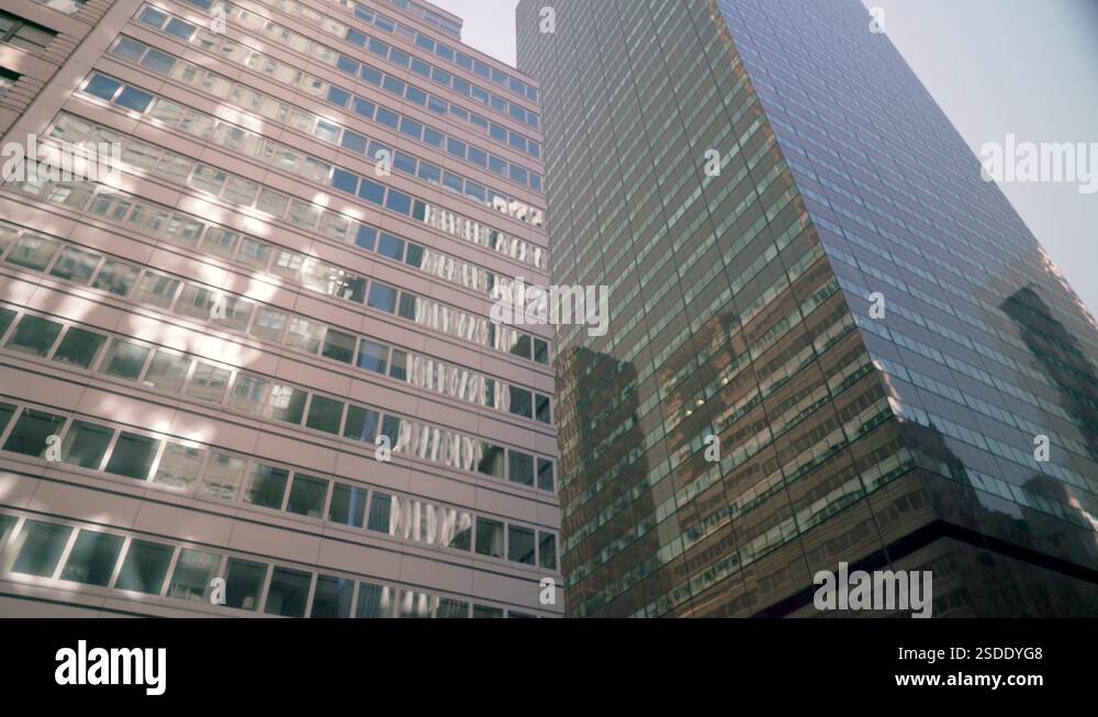 Slowly looking up at towering skyscrapers lining a street in New York ...