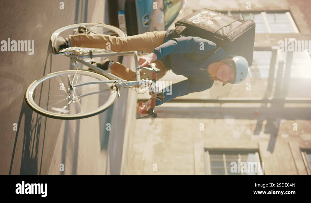 Happy Food Delivery Courier Rides a Bike on Road To Deliver Orders for ...
