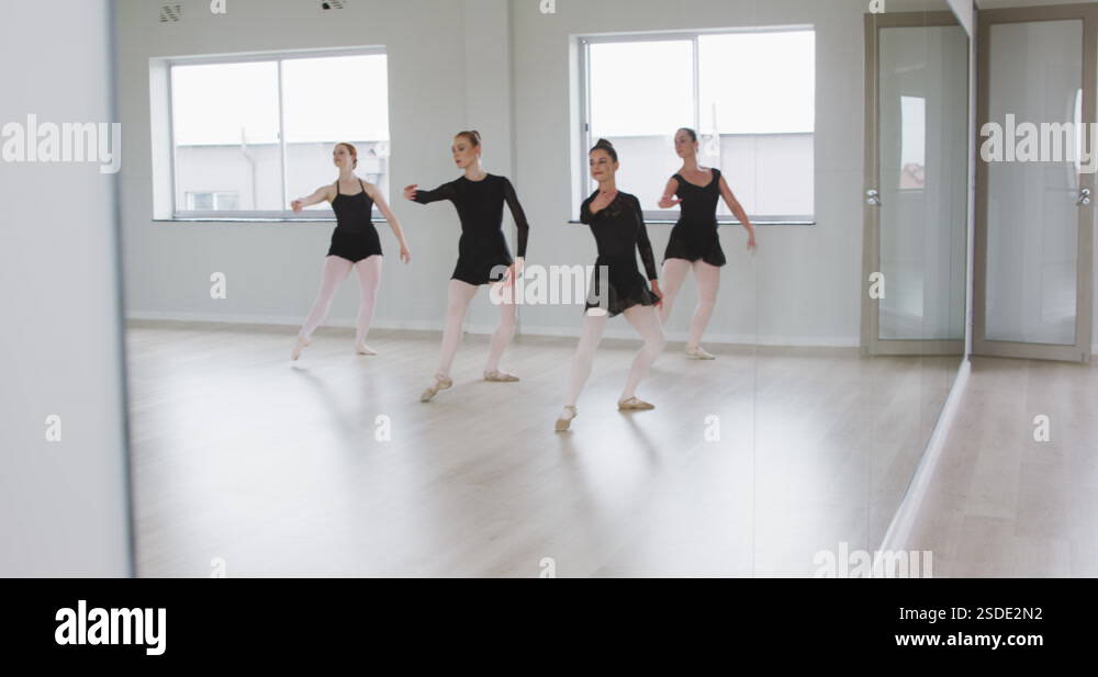 Caucasian female ballet dancers practicing a dance routine during a ...