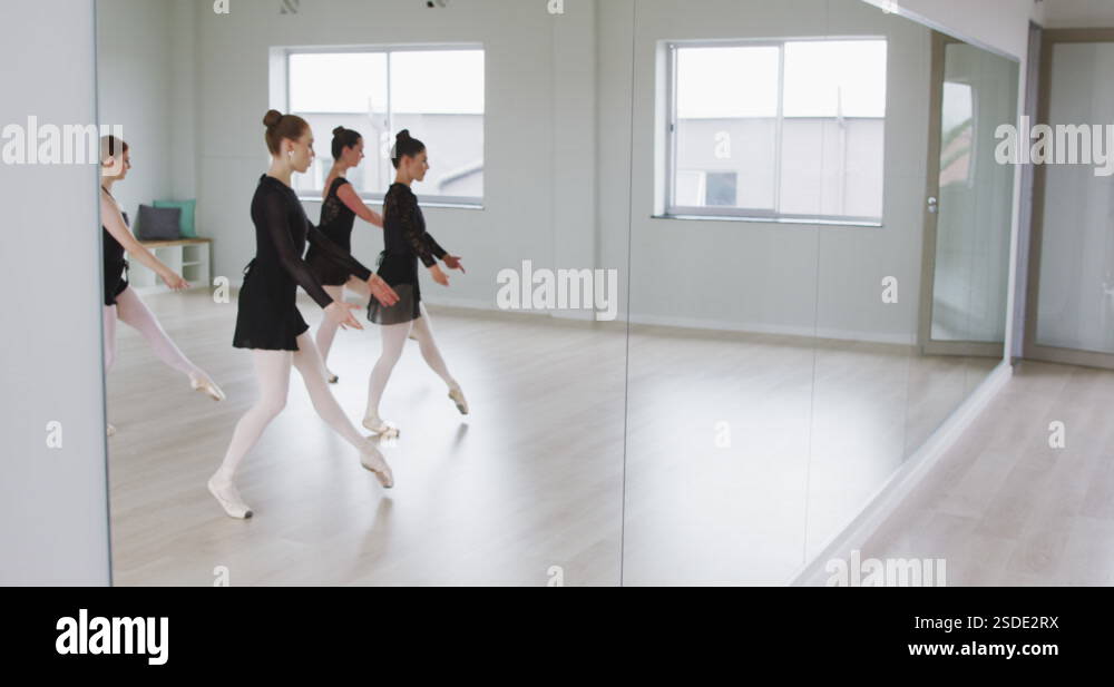 Caucasian female ballet dancers practicing a dance routine during a ...