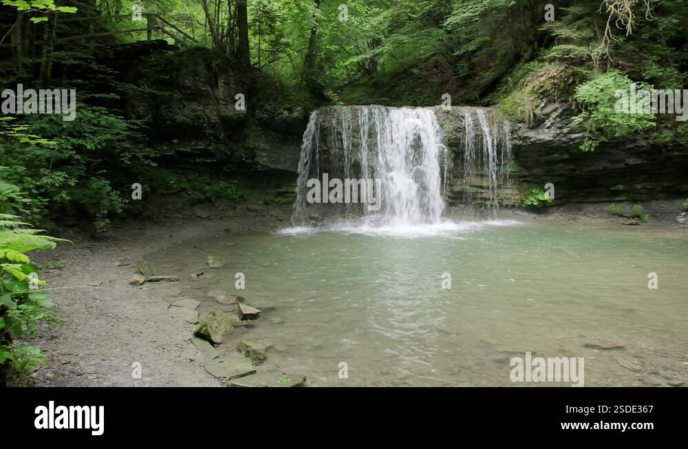 Camera pans around from left to right showing the waterfall and its ...