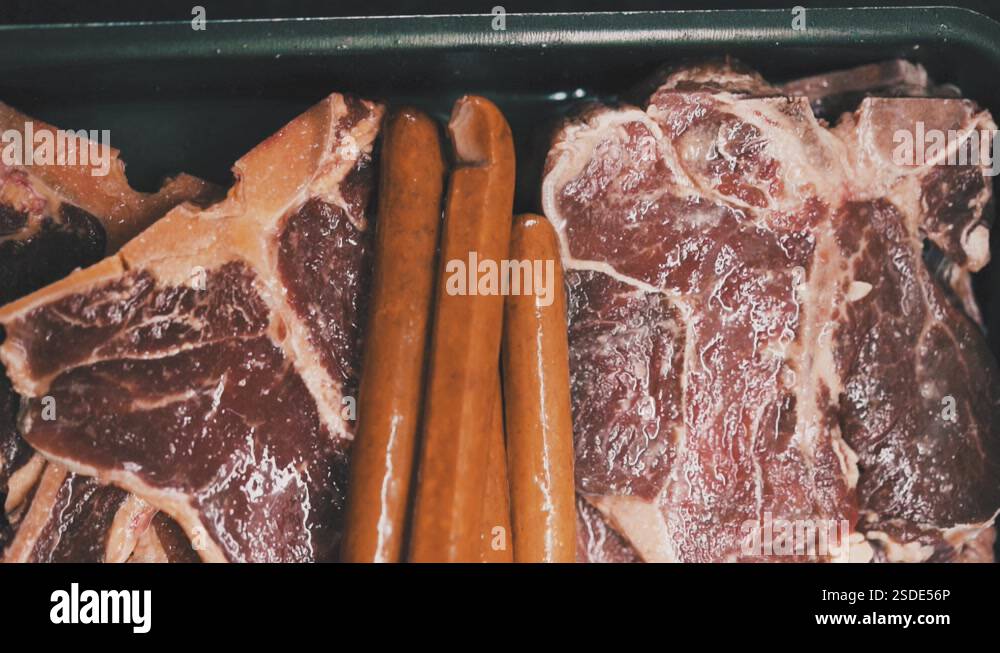 Tempering meat steaks and sausages for barbecue top down cinematic shot ...
