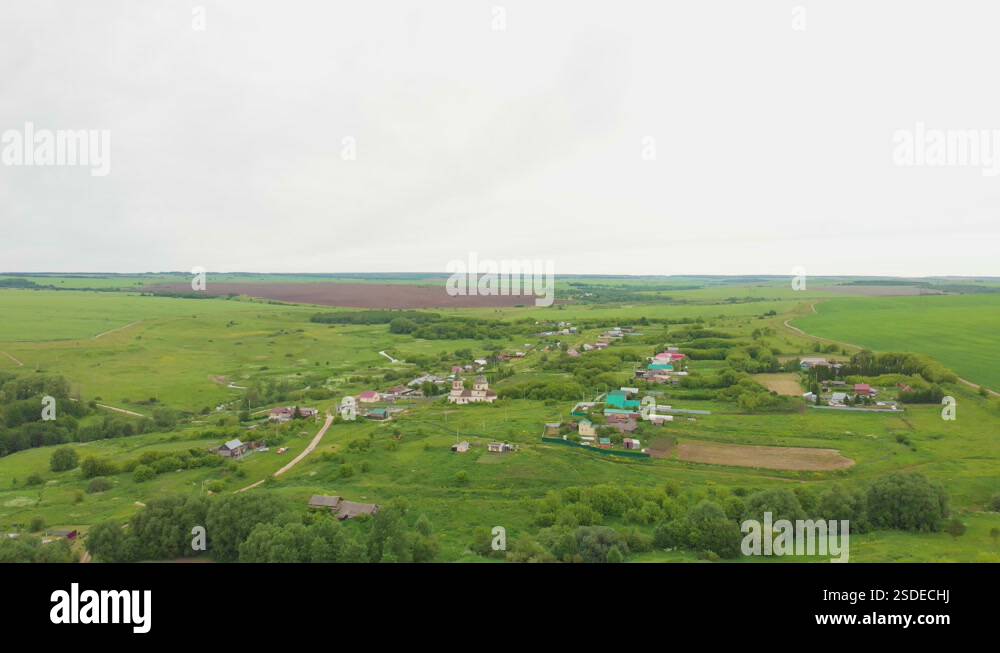 Green open field and a village Stock Video Footage - Alamy