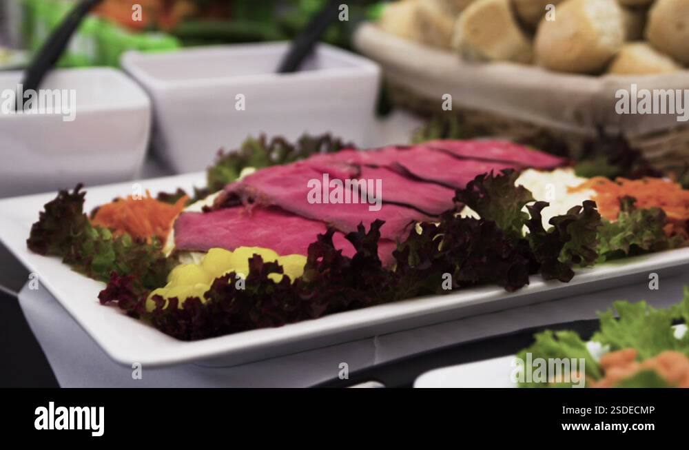 Buffet display with a tray of roast beef, small pickled onions and ...