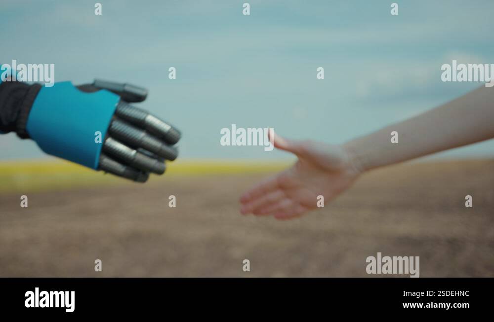 Robot and human handshake. Female hand and android cyborg hand visible ...