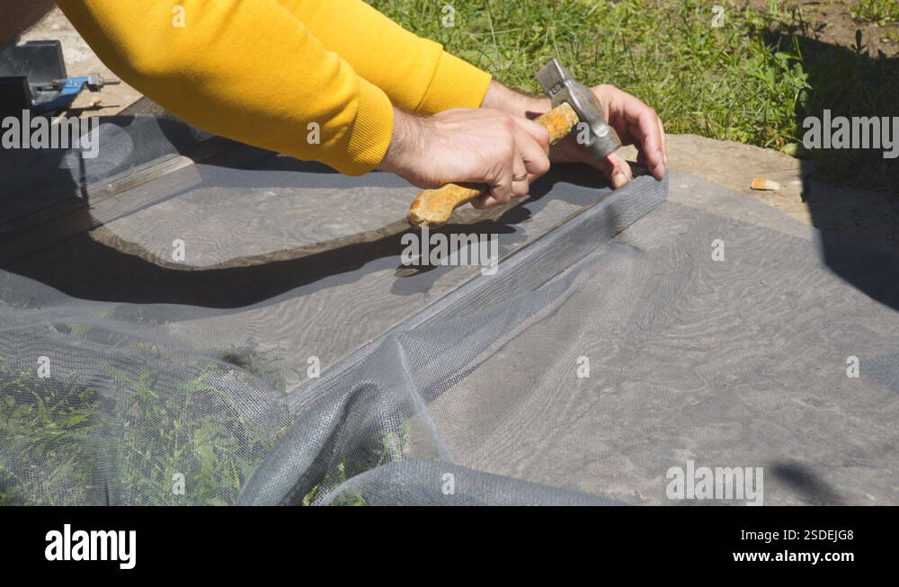Carpenter nails a mosquito net on the window Stock Video Footage - Alamy