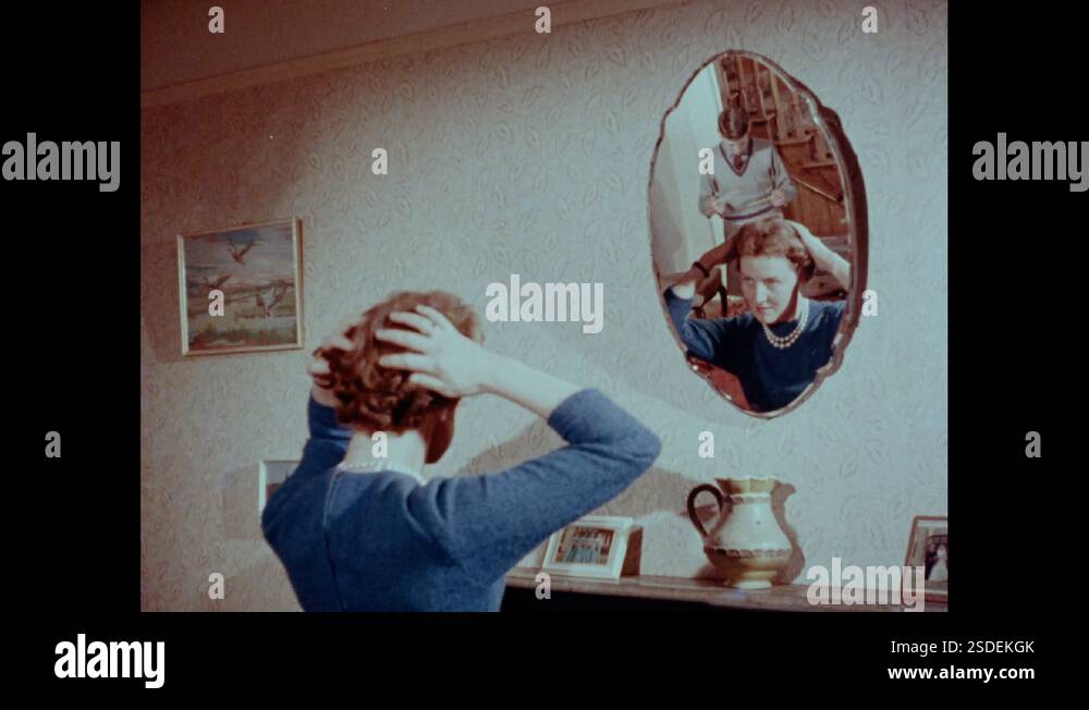 Boy brings mail to a lady making her hair in front of a mirror, UK 1961 ...