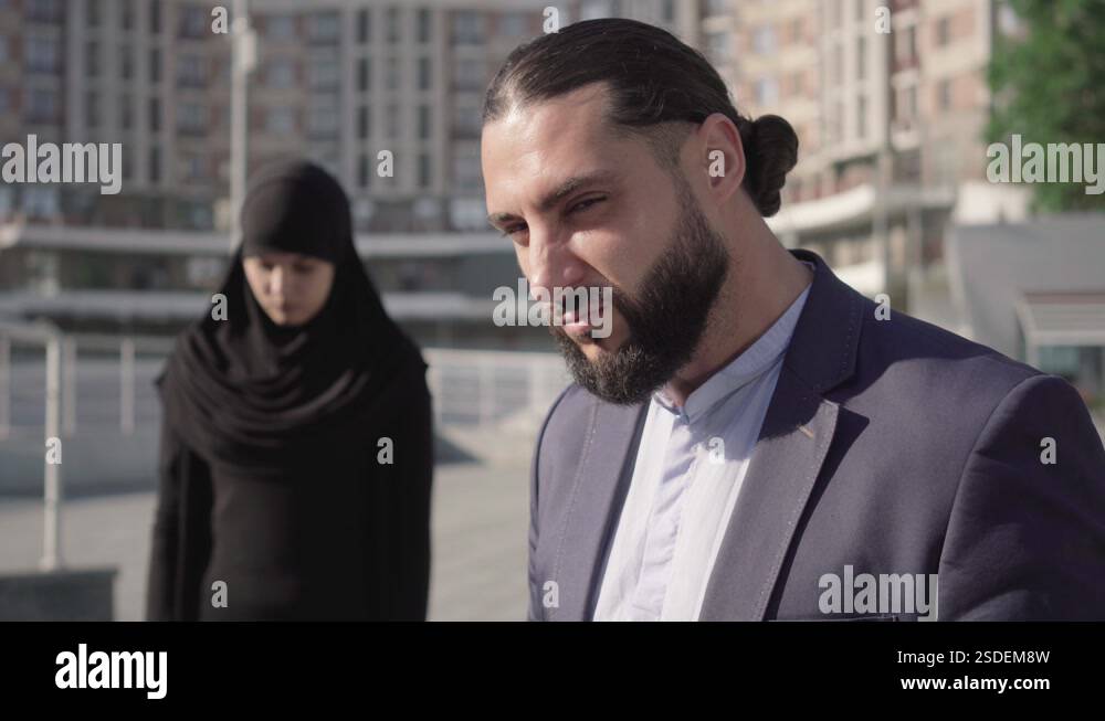 Close-up face of angry Middle Eastern man looking back at blurred ...