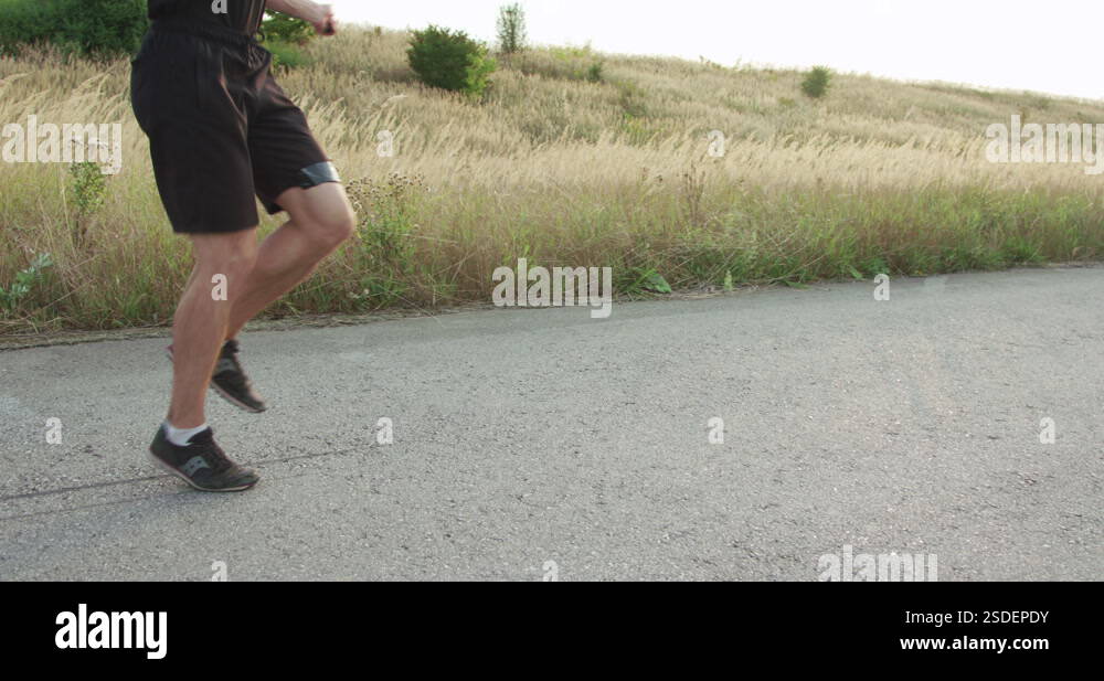 Kickboxer doing fast jump exercises on skipping rope on walkway at ...