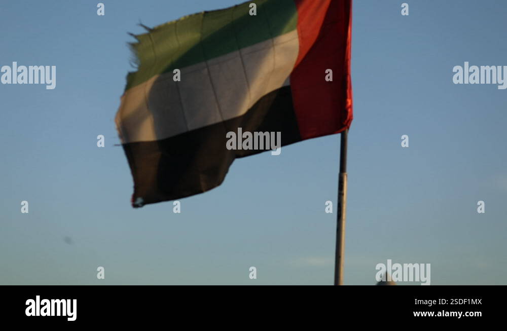 UAE Flag Blowing By The Wind Against A Summer Blue Sky In Deira Gold ...
