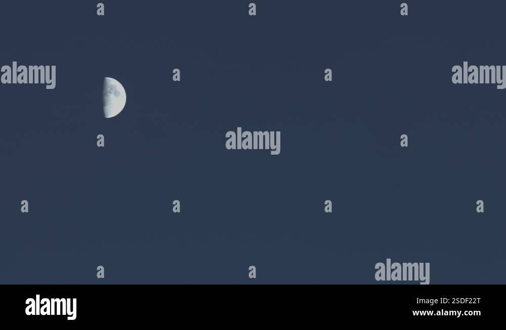 Half moon on the left third of frame in the evening sky Stock Video ...