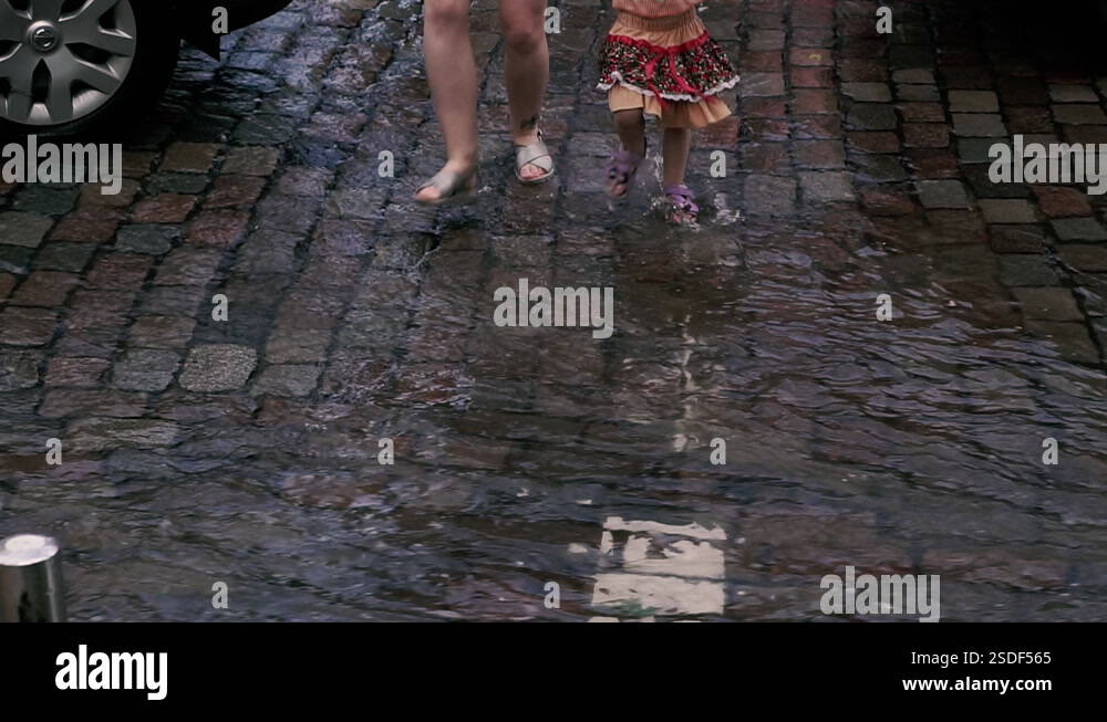 Flood. After heavy rain people cross puddles and flooded sections of ...
