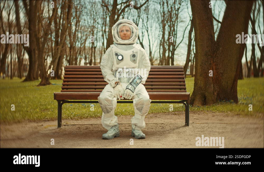 Sad Man in Spacesuit is Sitting on a Bench in a Park. Miserable ...