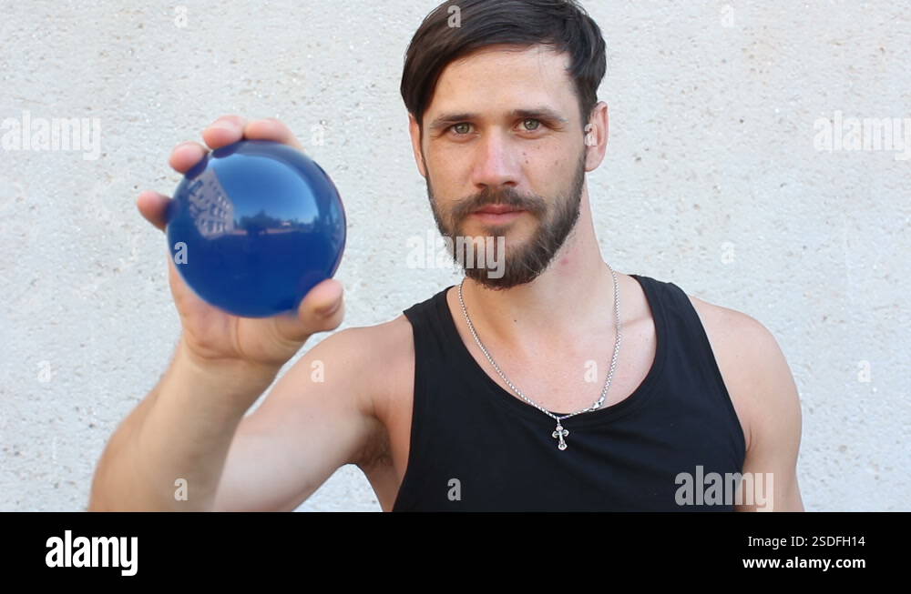 Young attractive guy is engaged in contact juggling. A man is juggling ...