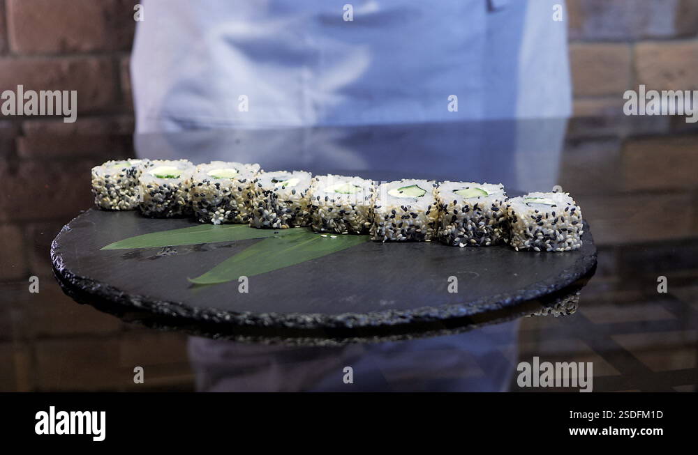 The process of sushi maki cooking, chef applying creamy tobiko tops on ...