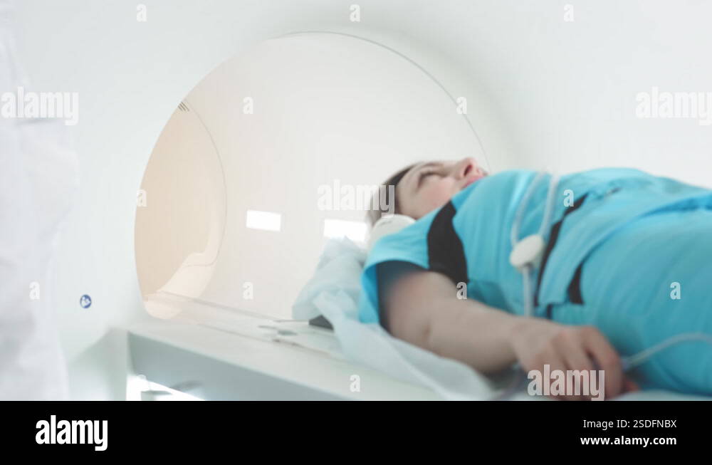 The doctor performs an MRI scan for a patient at the clinic. The girl ...