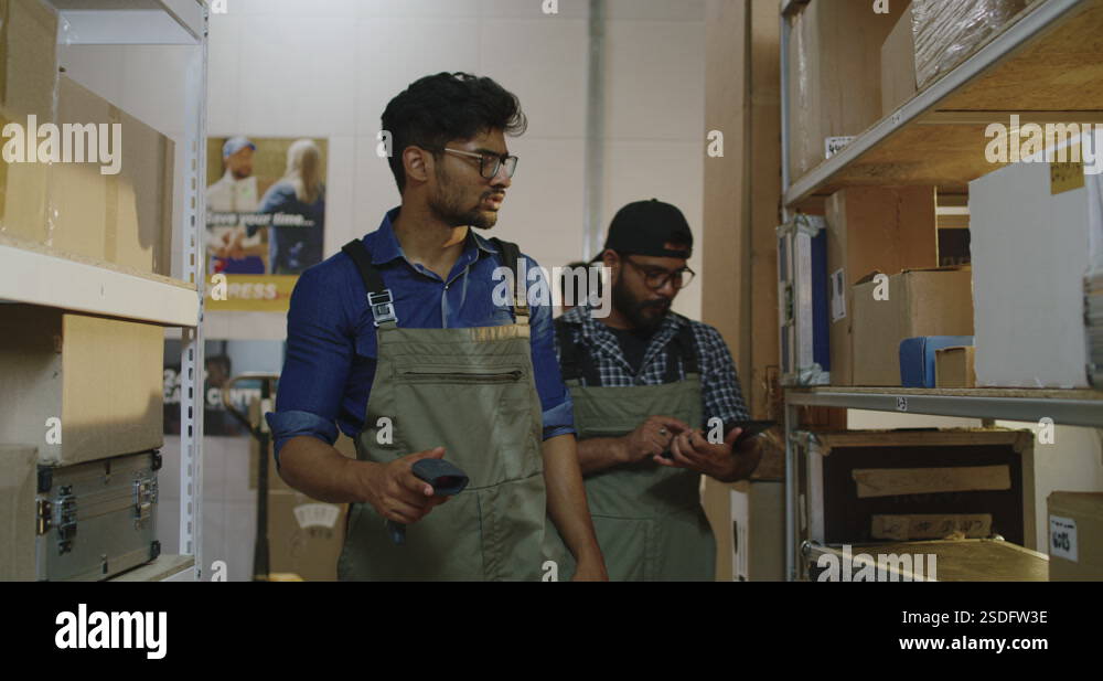 Workers checking packages in warehouse Stock Video Footage - Alamy