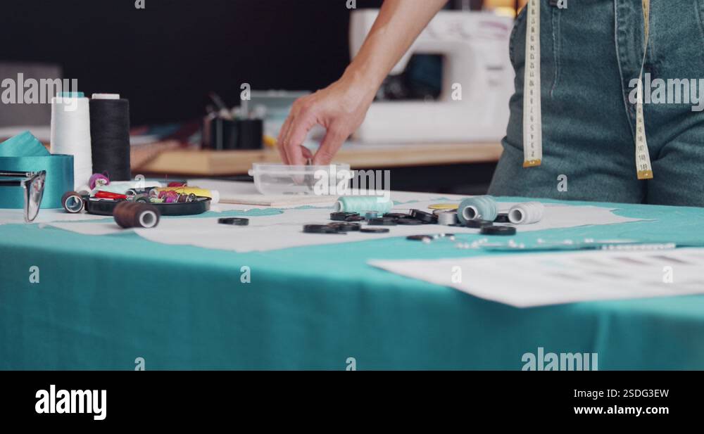 Fashion designer examining buttons, fabric and threads Stock Video ...