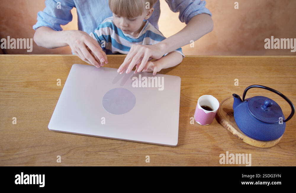 Close up mother with preschool child typing on laptop keyboard, little ...