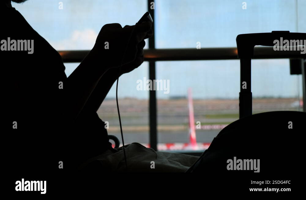 He is bored to wait the flight, mobile helps to kill the time Stock ...
