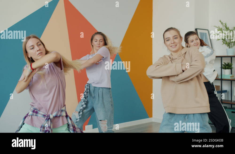 Beautiful girls in trendy clothing dancing in modern dance school ...