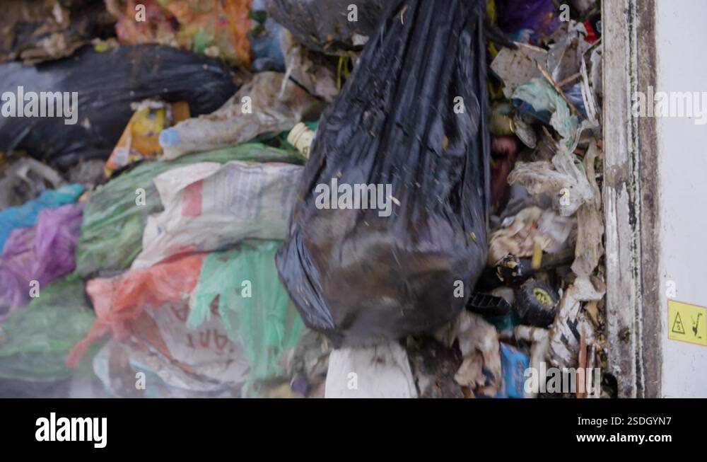 Slow motion close up of plastic waste being dumped by a garbage truck ...