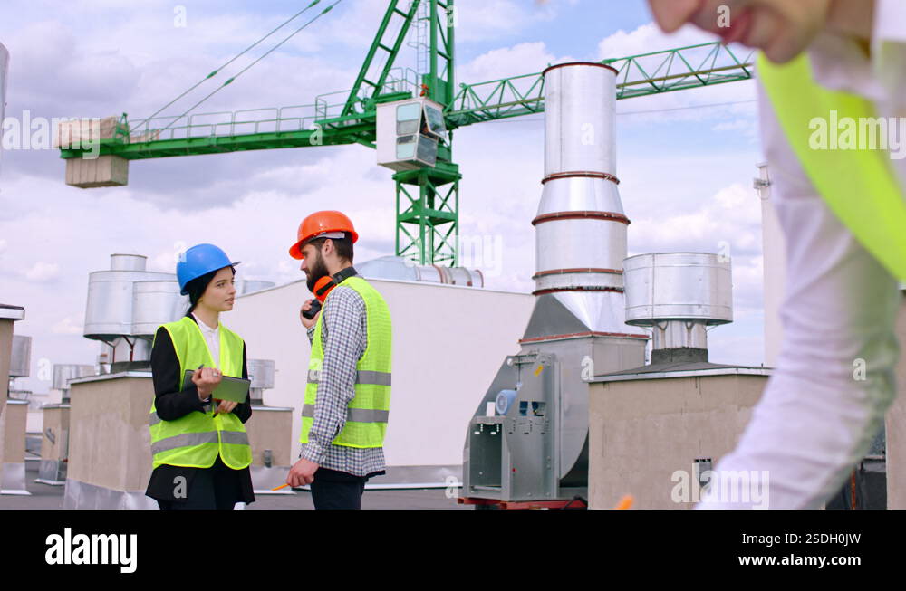 Big construction site on the top of the building lady and guy engineers ...