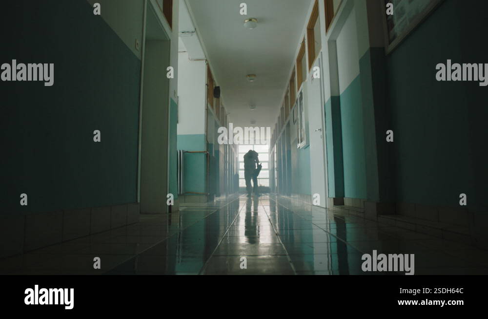 This video shows a man in protective overalls sanitizing a corridor ...
