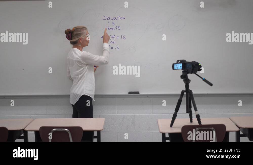 Push in shot of woman teacher giving a virtual math class online to ...