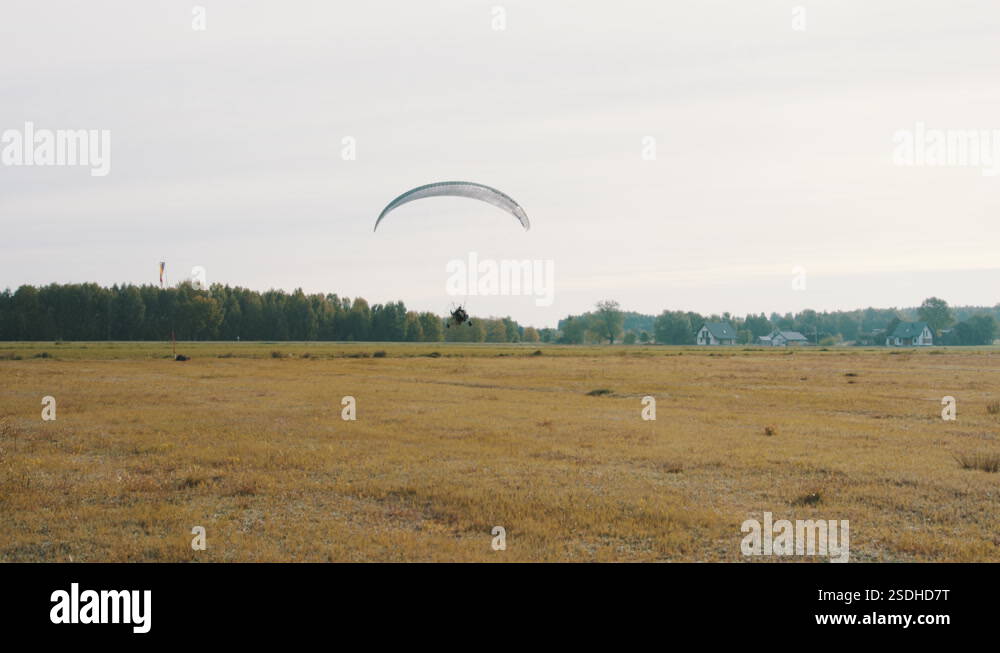 Landing with the tandem paramotor gliding in slow motion. Wide shot ...
