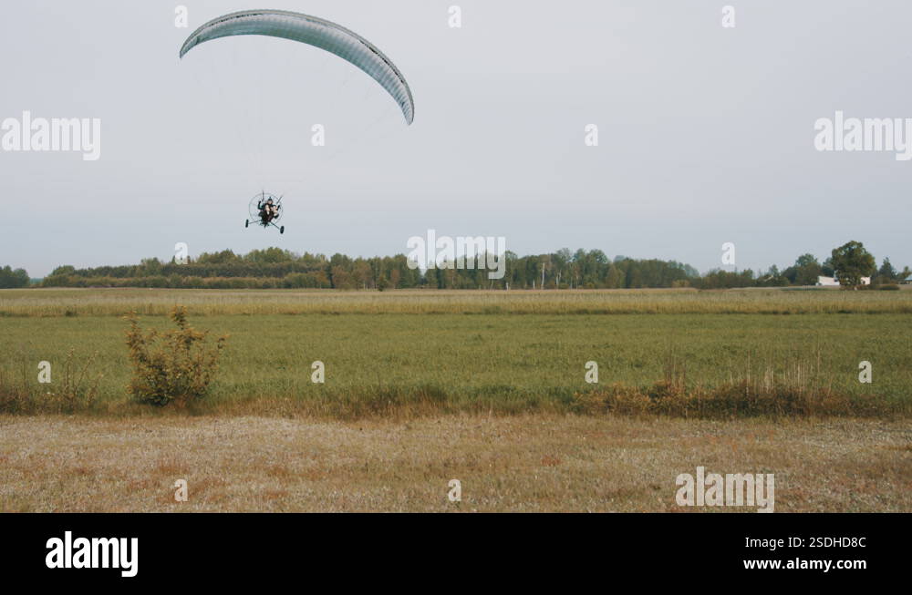 Landing with the tandem paramotor gliding in slow motion. Wide shot ...