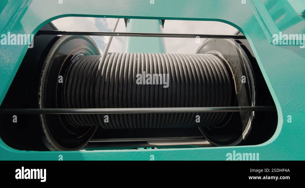 Drum hoist winch. A winch unwinds a steel cable close-up. Hoist drum ...