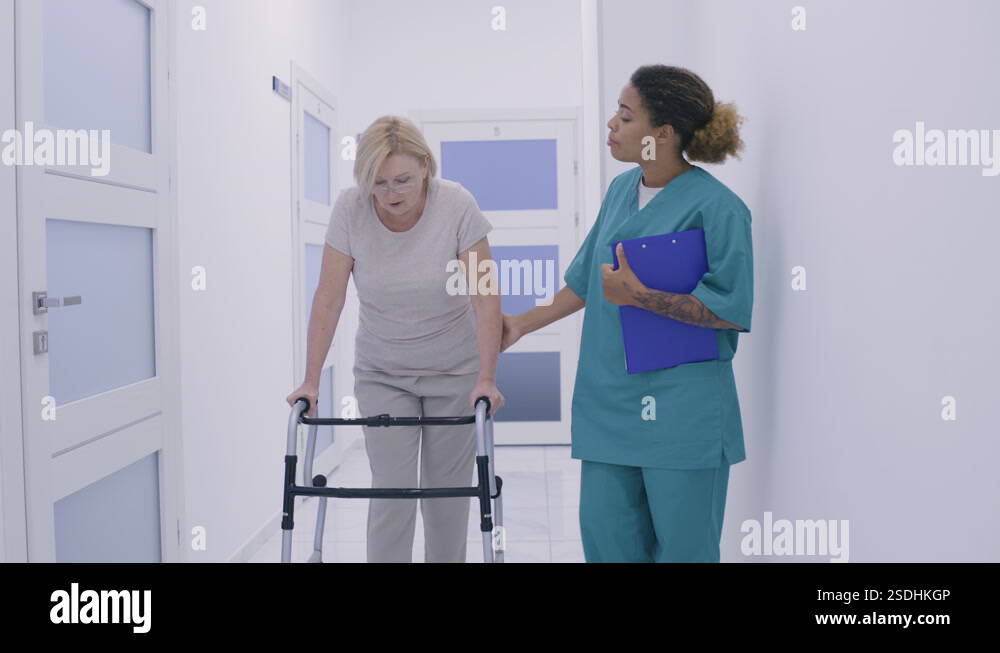 Rehabilitation after disease doctor helping weak female patient walk ...