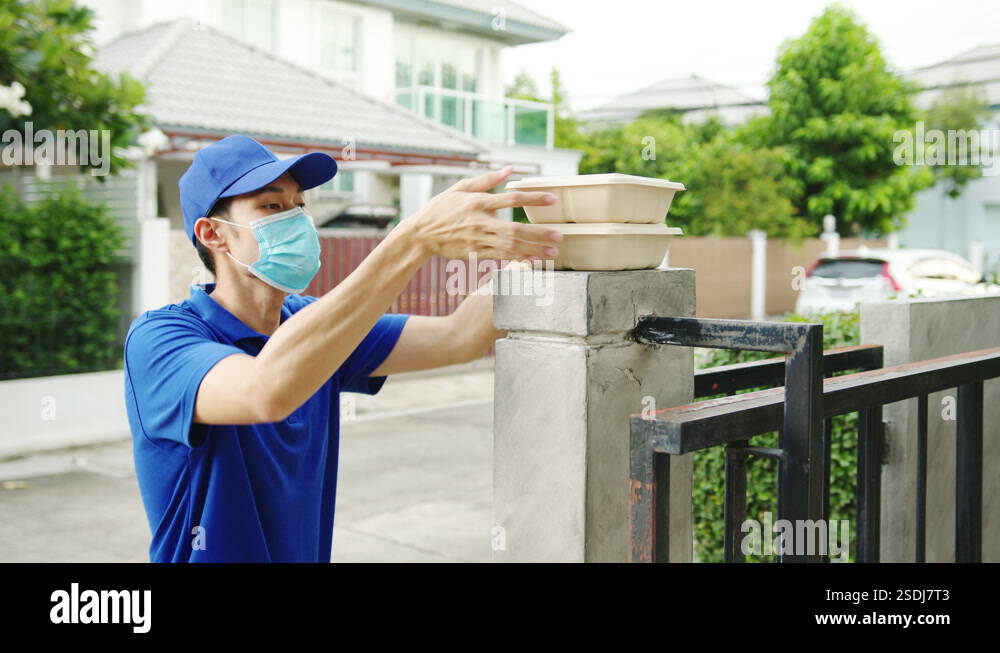 Young delivery man wear face mask handling food box for send to ...
