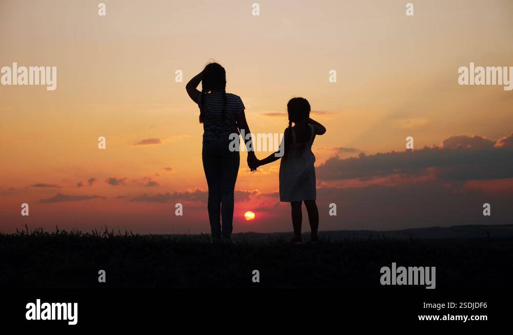 happy family two sisters sunset walks at in the park silhouette say ...
