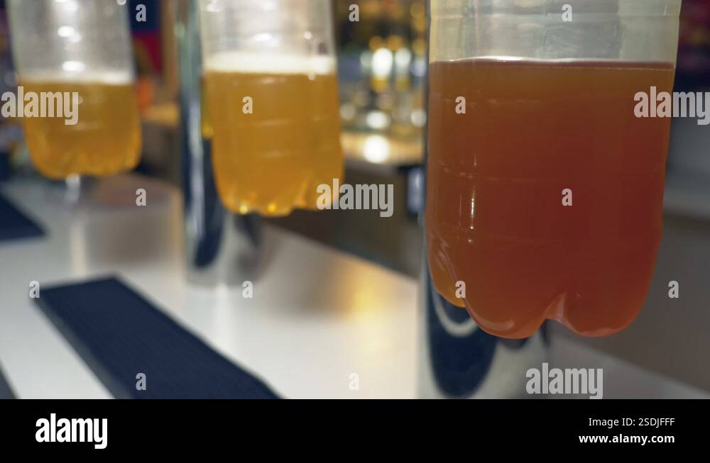 draft beer of different varieties is poured from taps into plastic ...