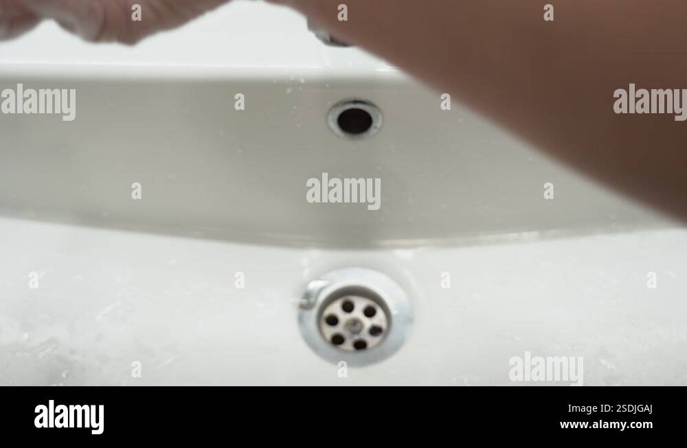 Woman washing hands carefully using whirte bar of soap and fresh water ...