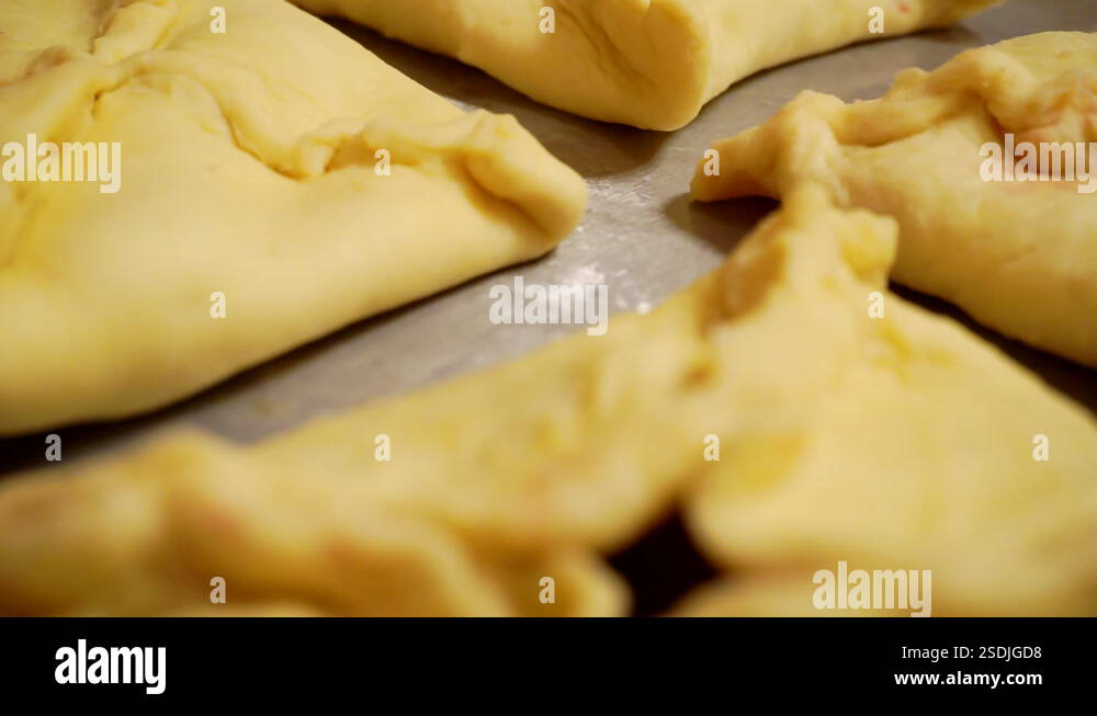 hand molded sweet pies on the baking sheet before being sent to the ...