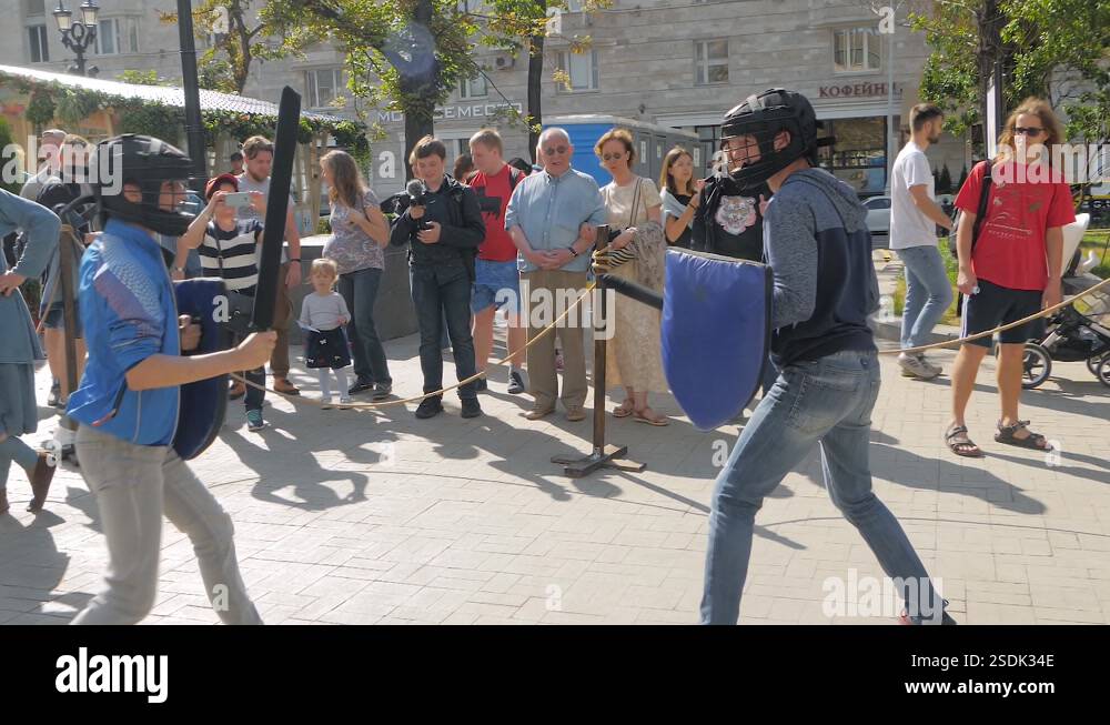 Two teen boys playing knights and fighting with toy sword and shield at ...
