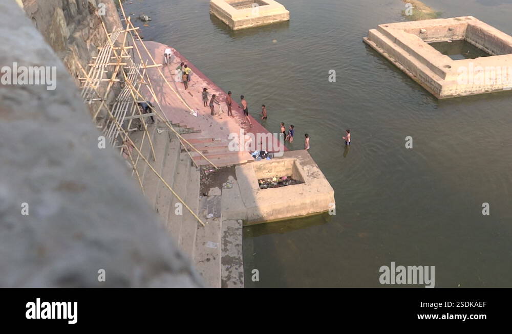 Wide, high angle, kids have fun on stone steps and in the river ...